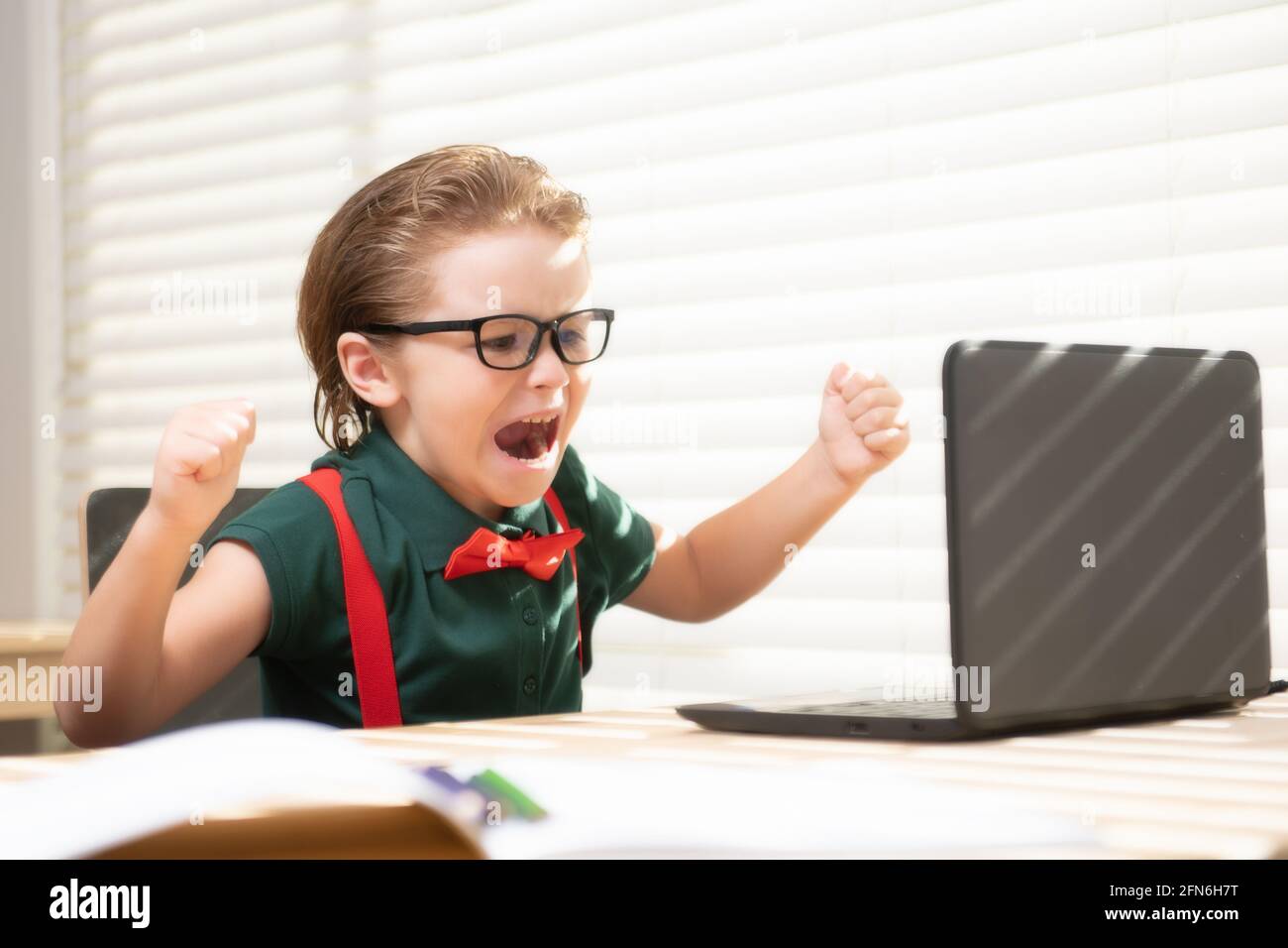 Smart school boy at home writing homework. Little student with notebook ...
