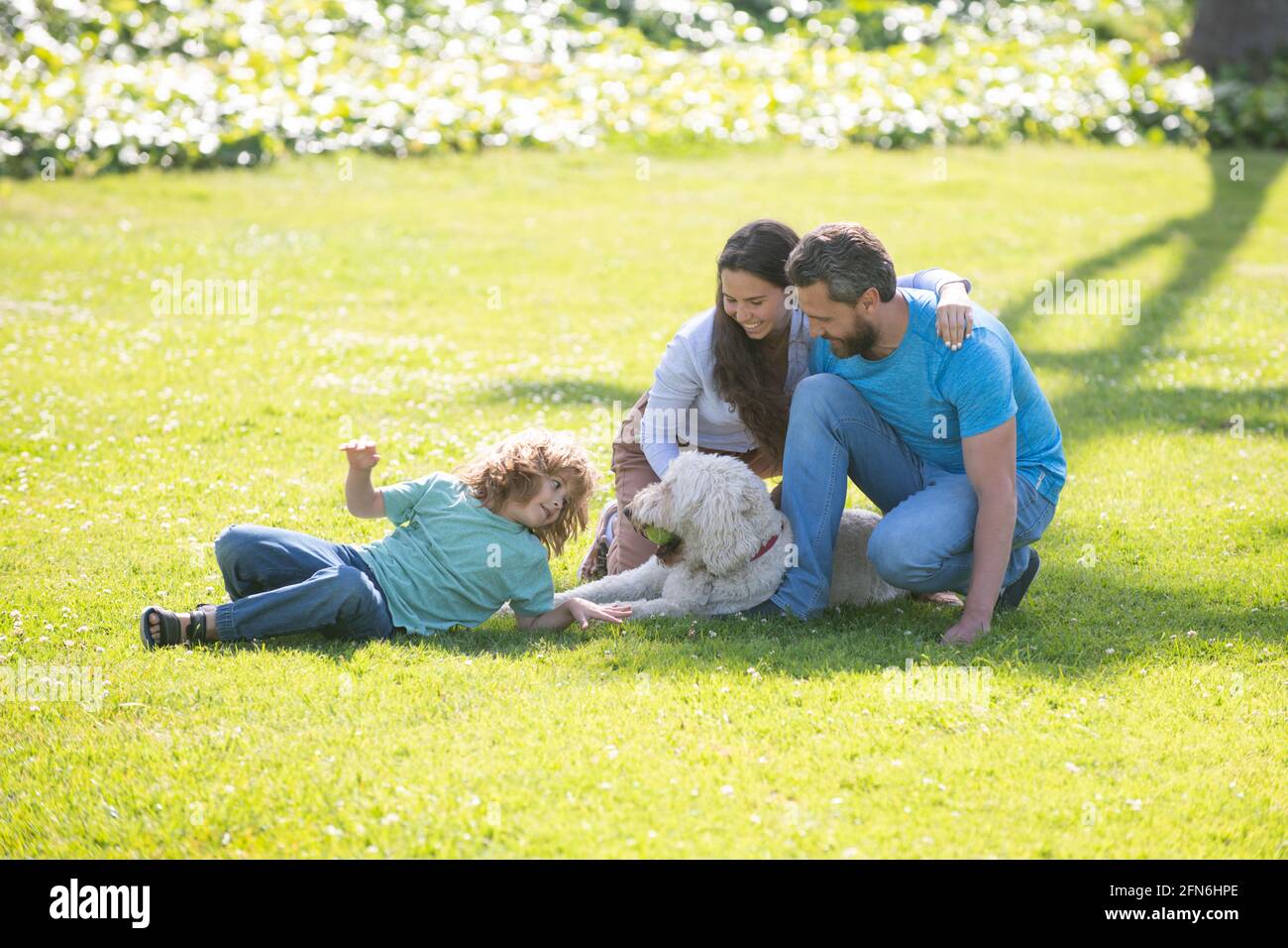 Beautiful happy family is having fun with dog outdoors. Cute family ...