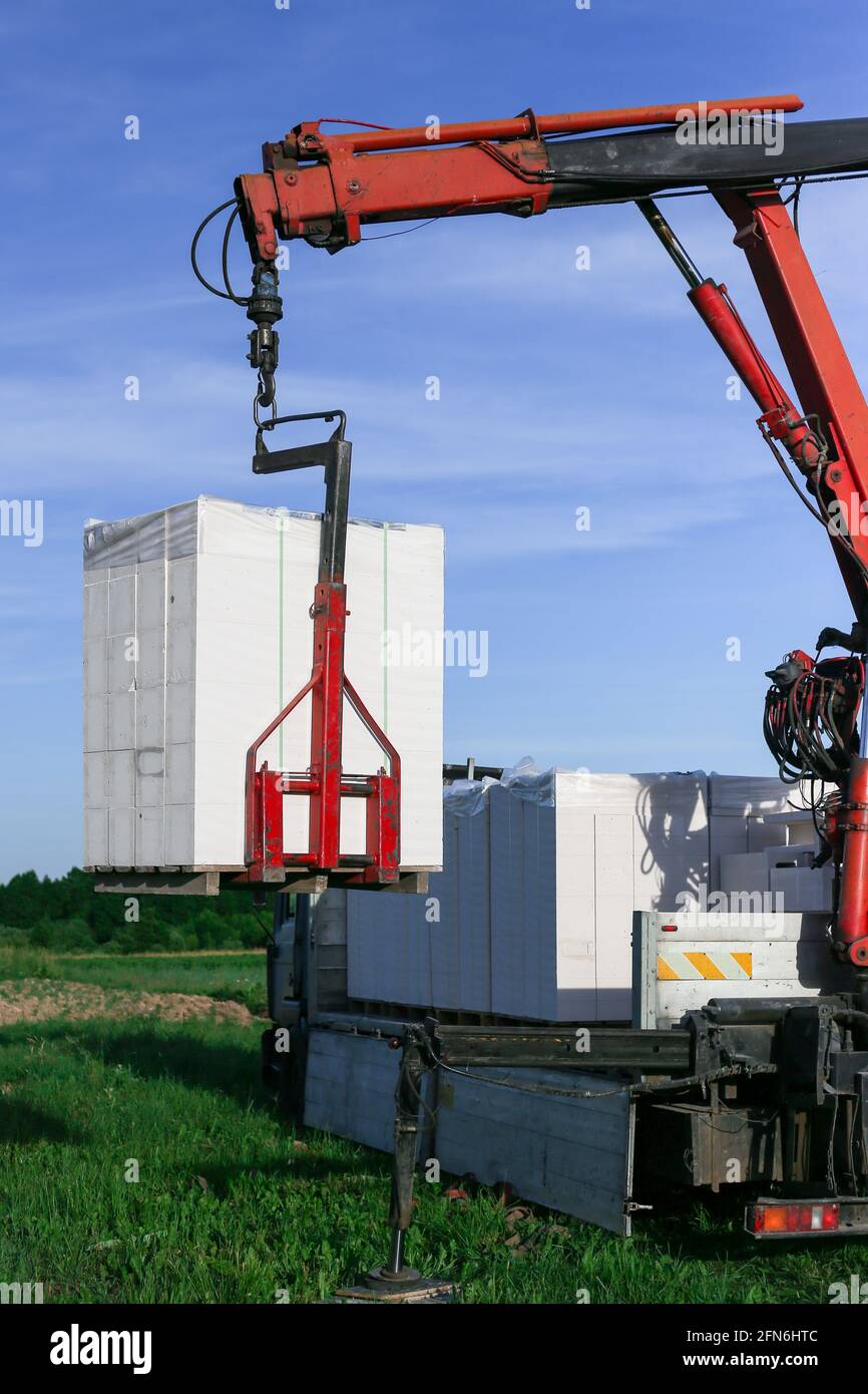 Unloading building blocks from a truck using a crane. Hydraulic ...
