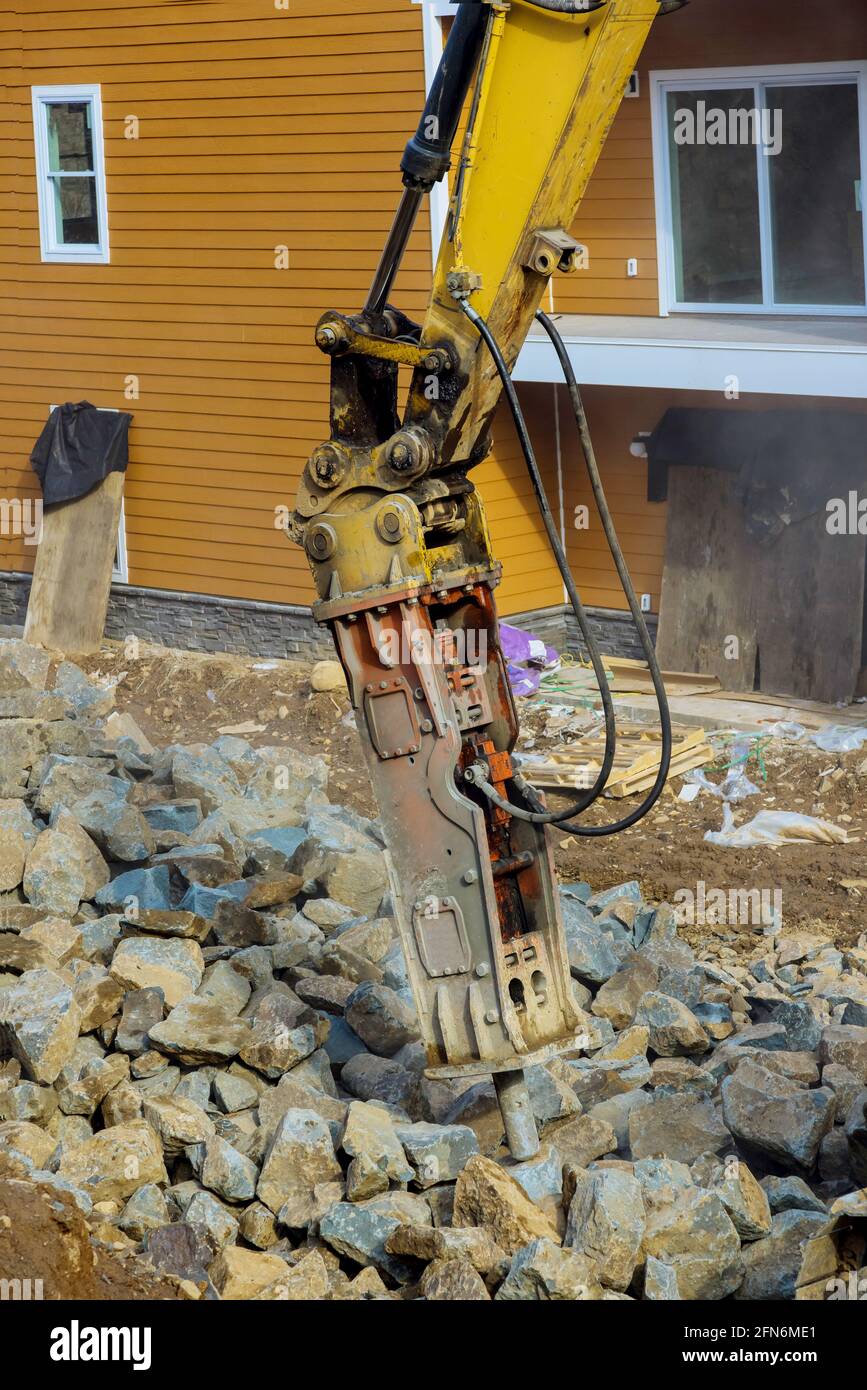 Large jackhammer smashing rocks in the new laying road around home ...