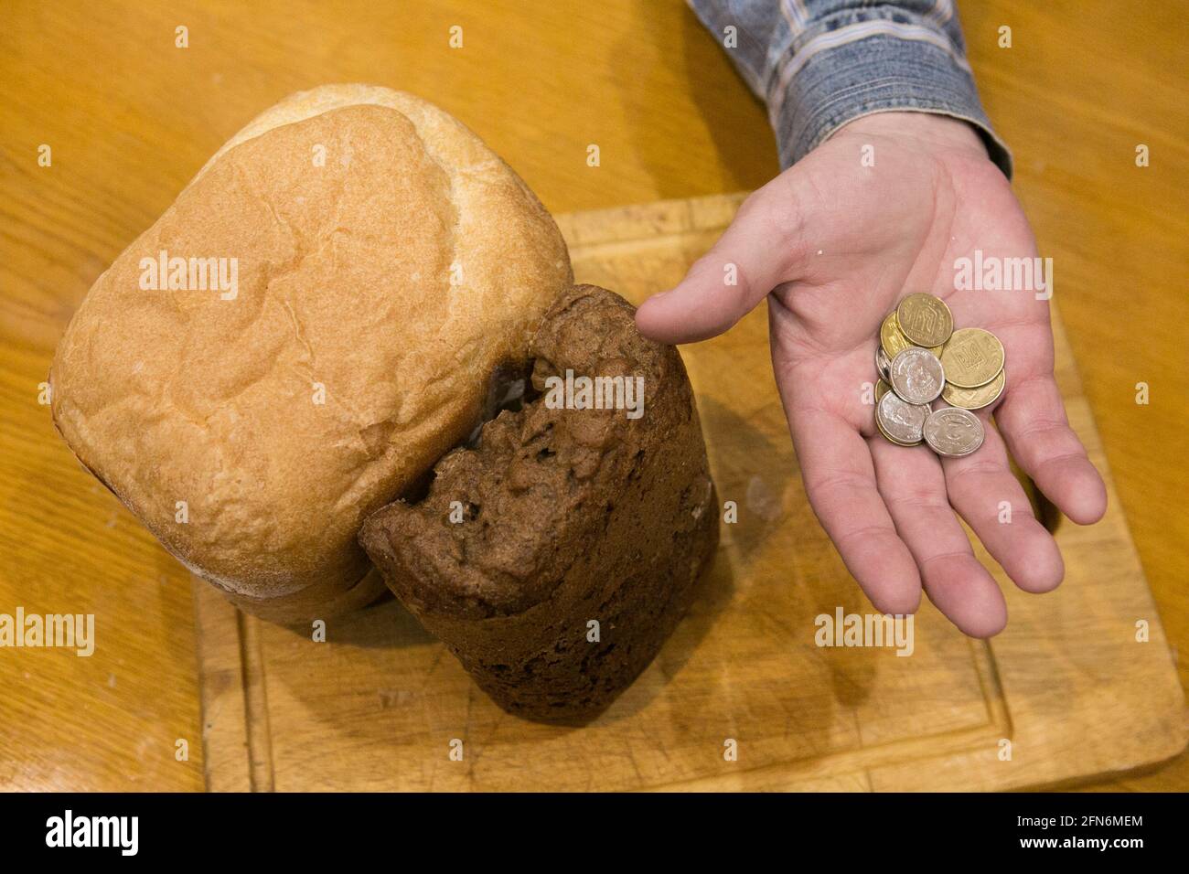 Last money to buy bread. A loaf of bread and the hand of an old man ...
