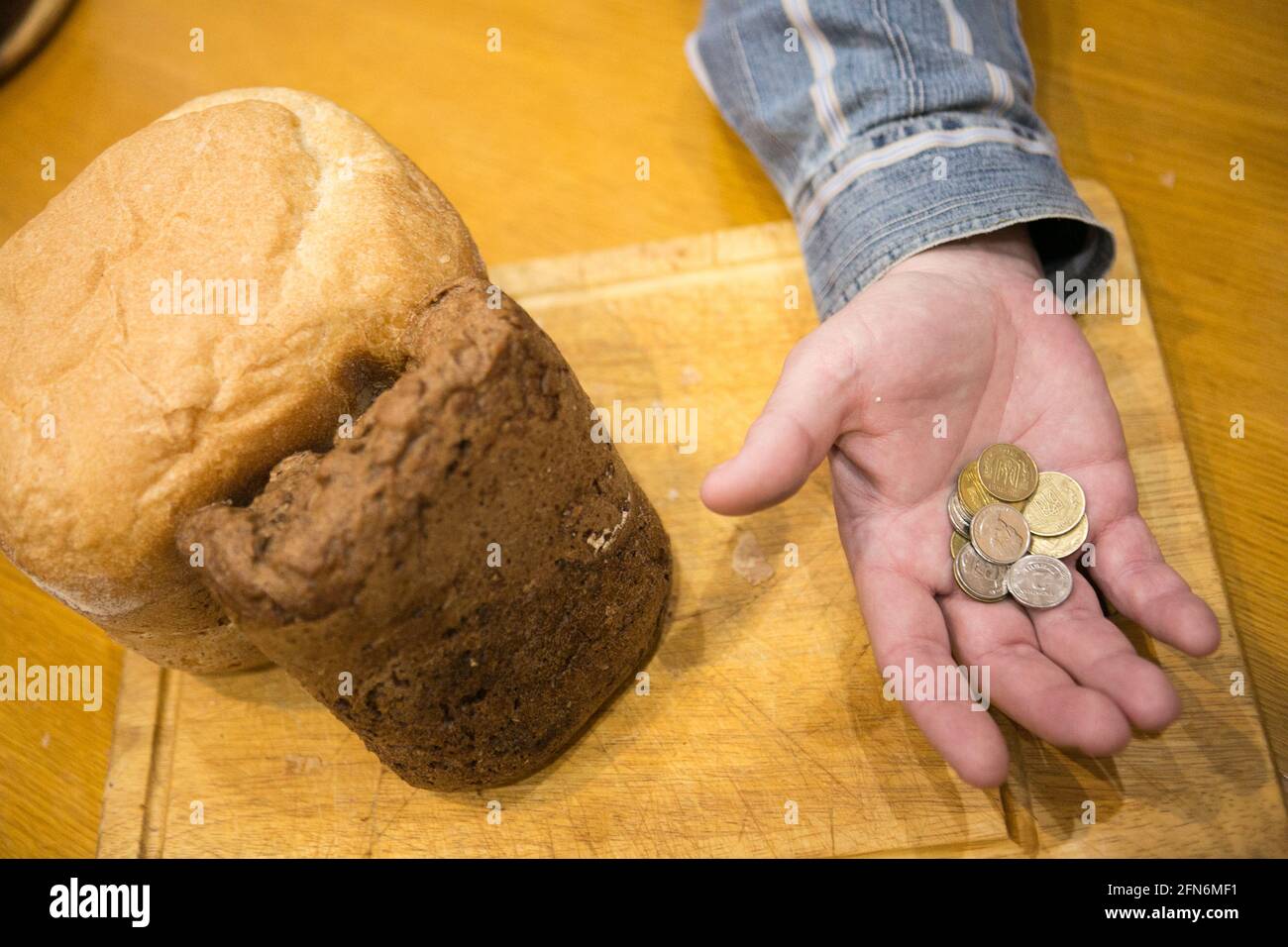 Last money to buy bread. A loaf of bread and the hand of an old man ...
