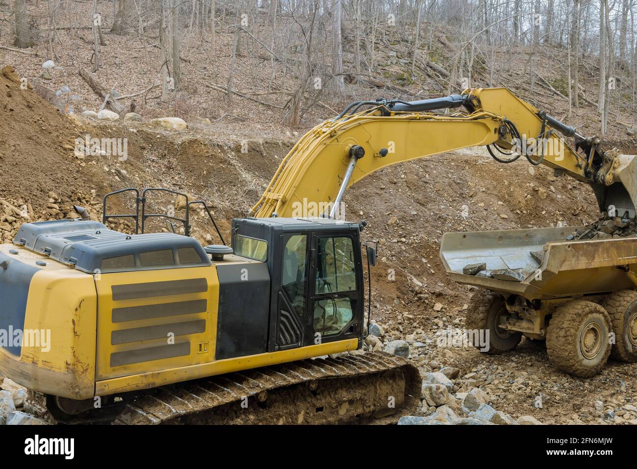 Tractor loads with stone a dump trucks transporting for processing ...
