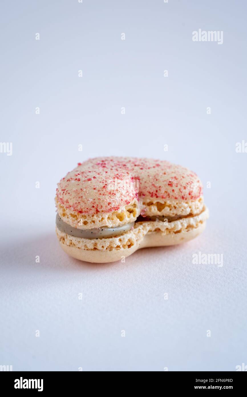 A single vanilla flavoured heart-shaped French macaron, copy space on ...