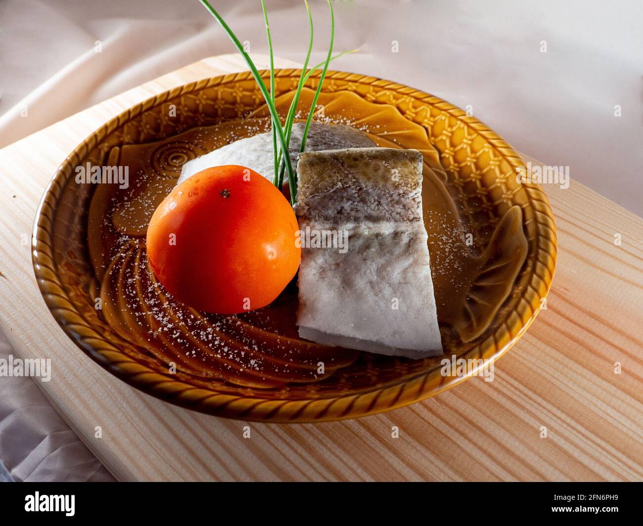 High angle shot of slightly salted raw fish fillets with green onion ...