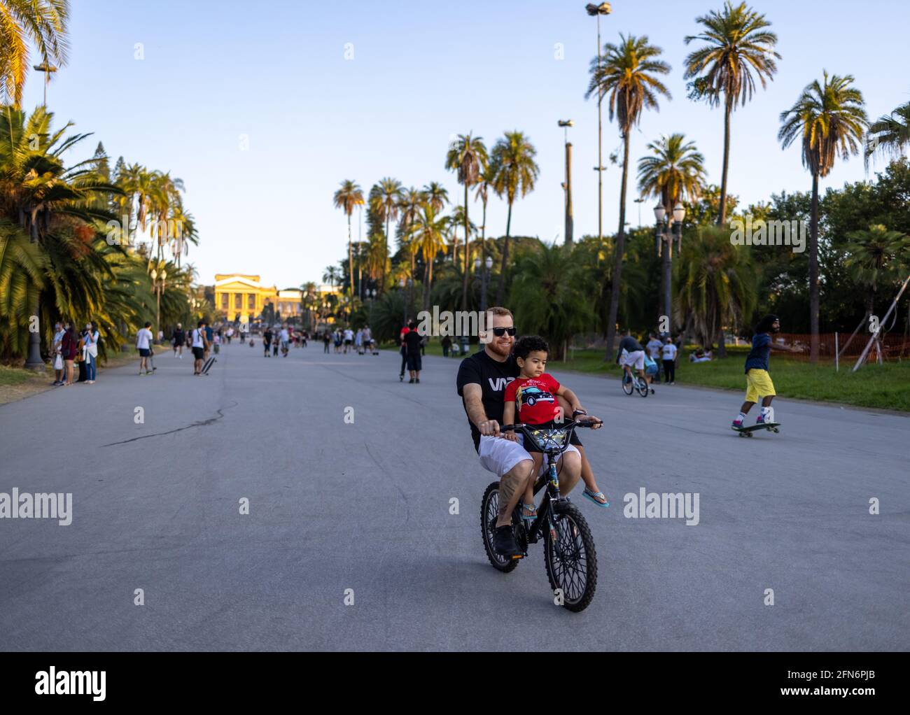 Children and adults having fun in the park with their skates ...