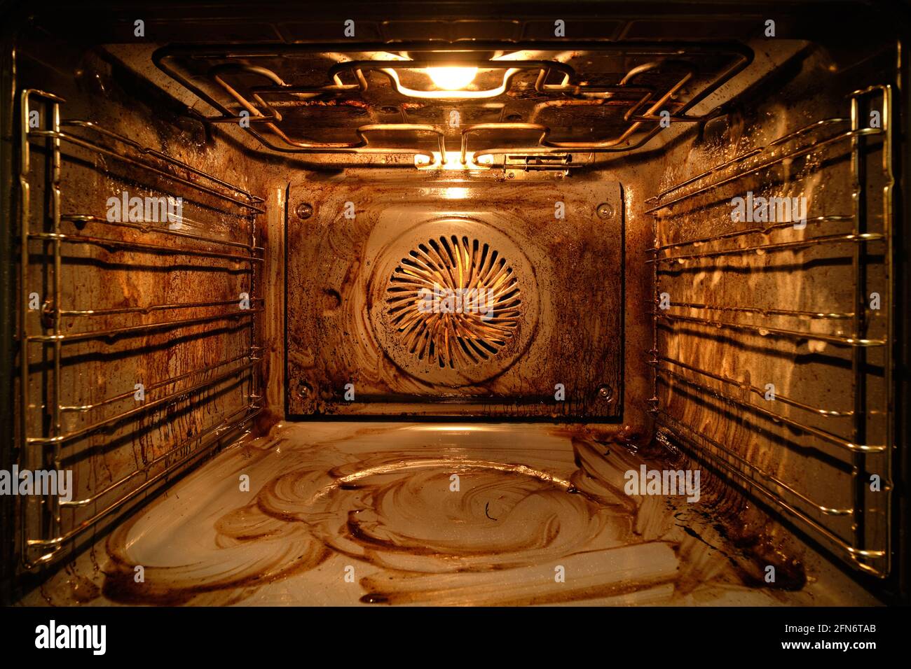 Dirty oven from traces of food inside with the light on Stock Photo - Alamy