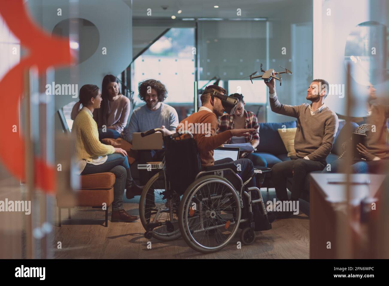 Disabled businessman in a wheelchair at work in modern open space ...