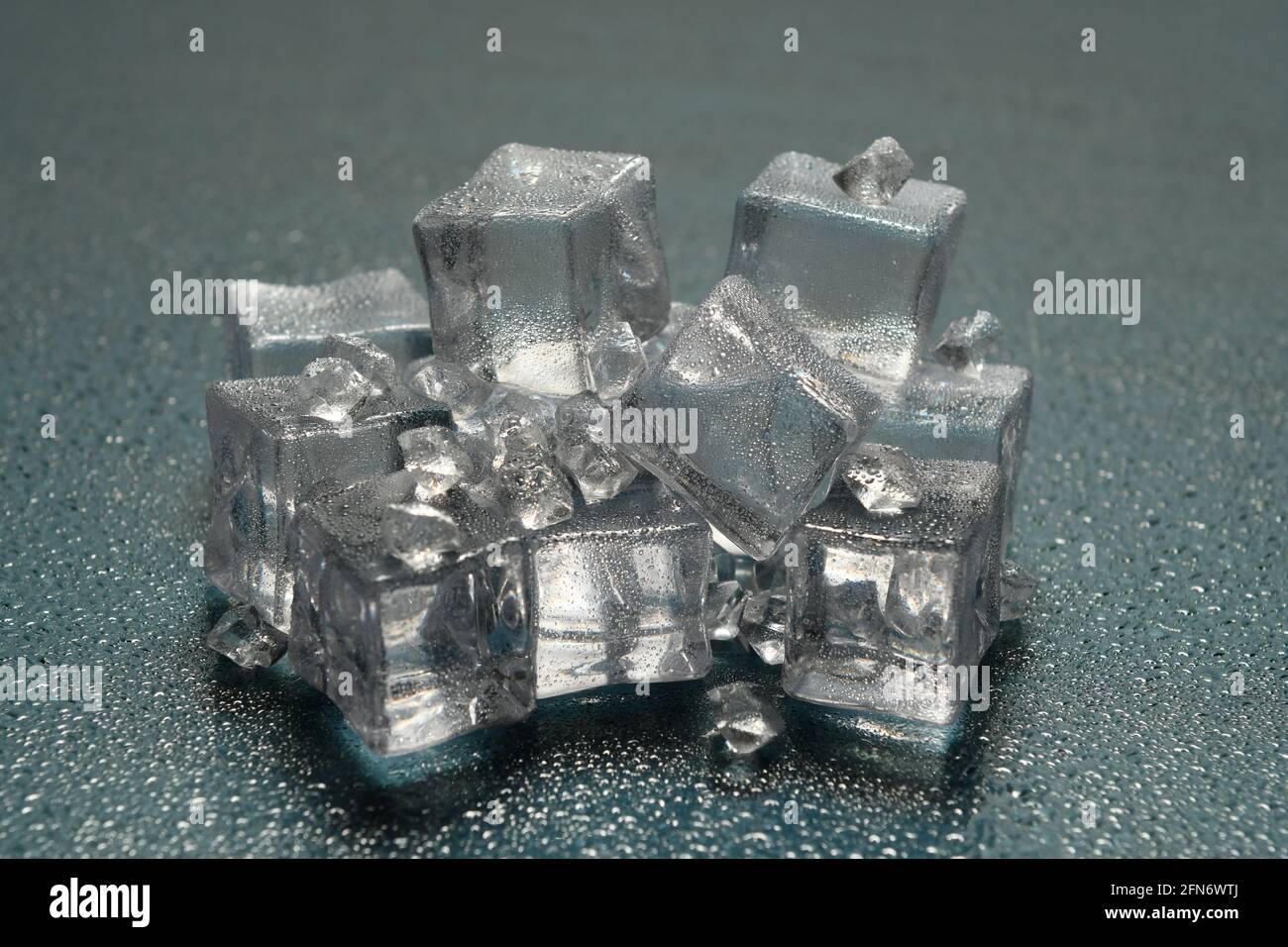 ice stone on reflective surface of background with drops, idea of a ...