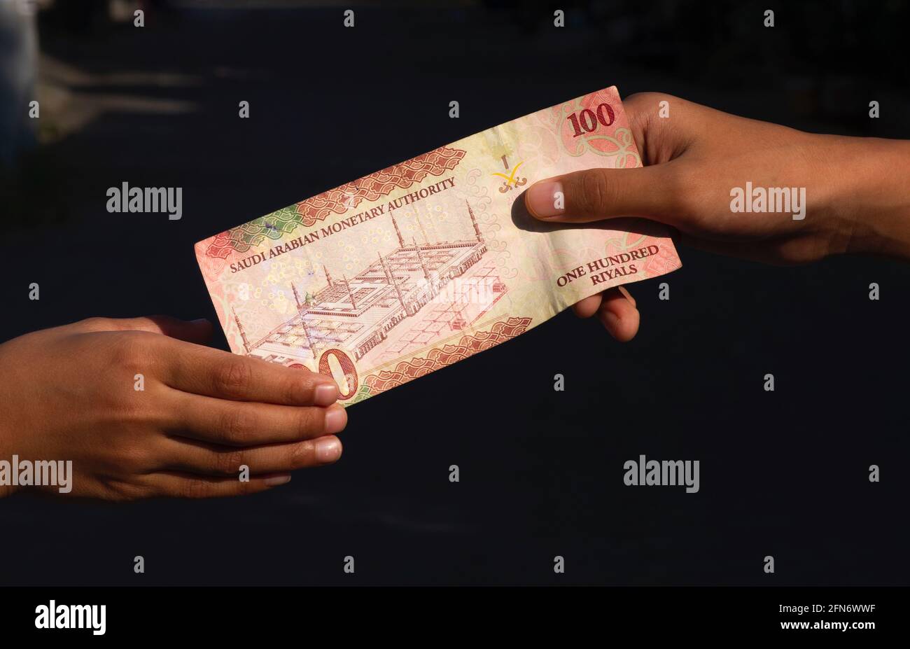 Asian children hand with 100 Riyal, the currency of Saudi Arabia ...