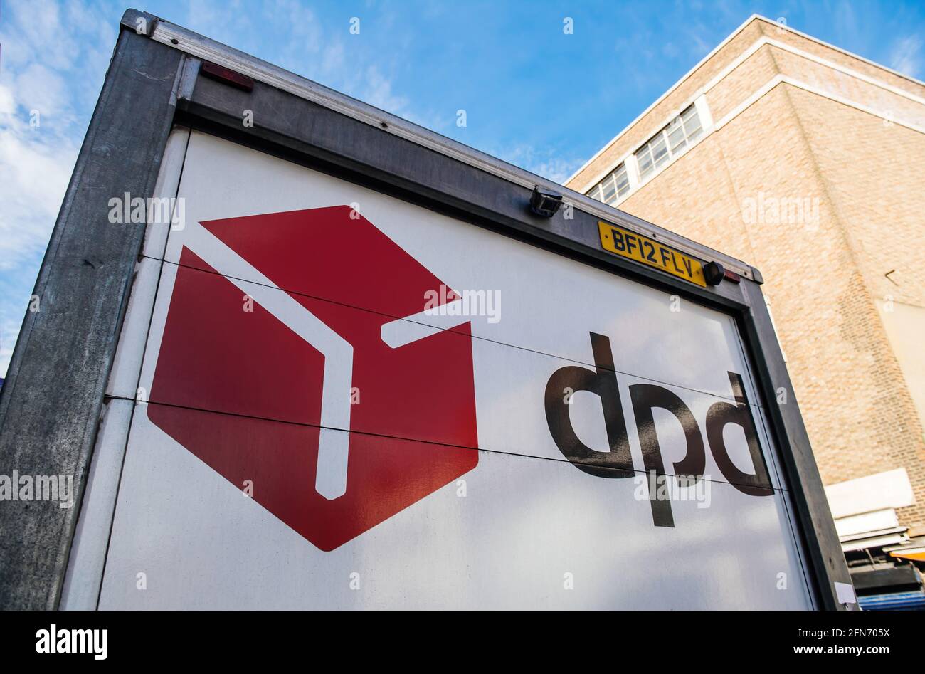 Low angle view of DPD parcel delivery van back in front of brick ...