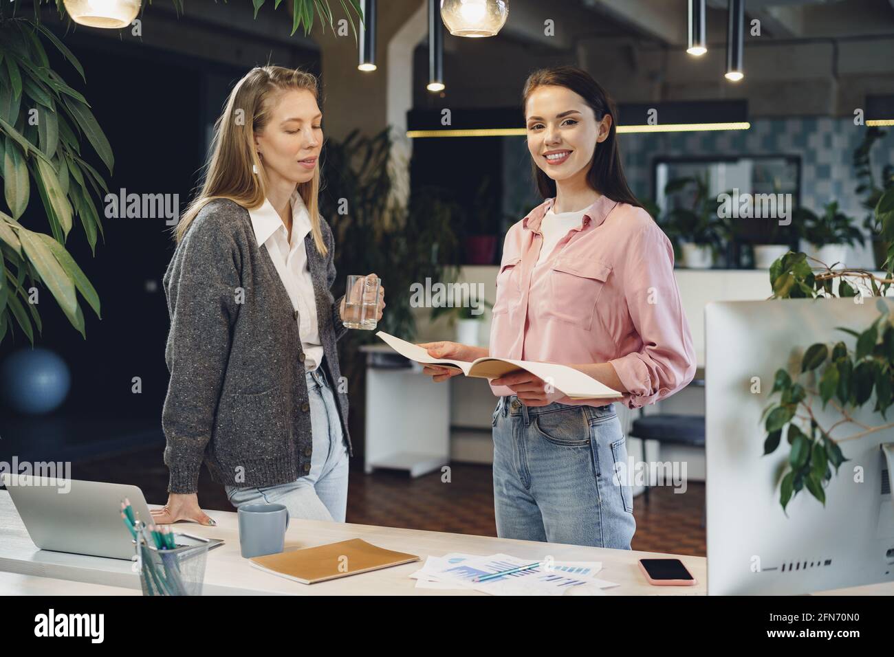 Two young women working together in office Stock Photo - Alamy