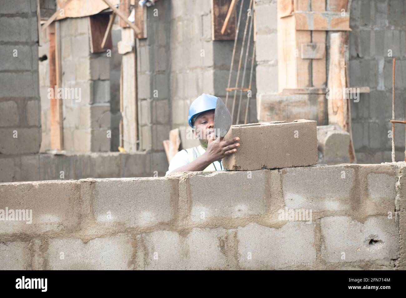 an african bricklayer laying bricks and holding a trowel Stock Photo ...