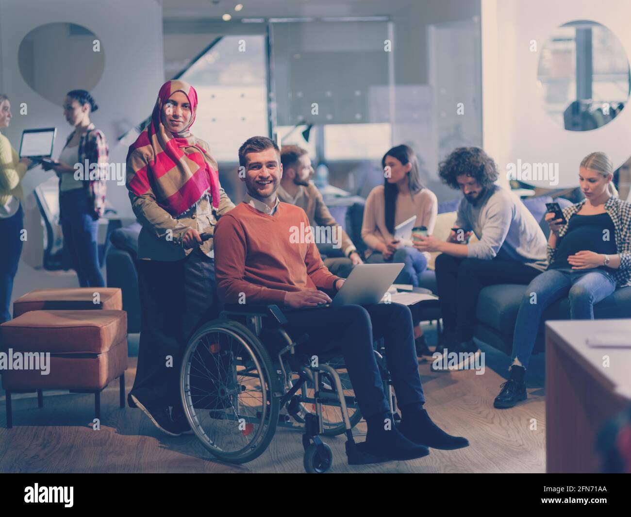 Disabled businessman in a wheelchair at work in modern open space ...