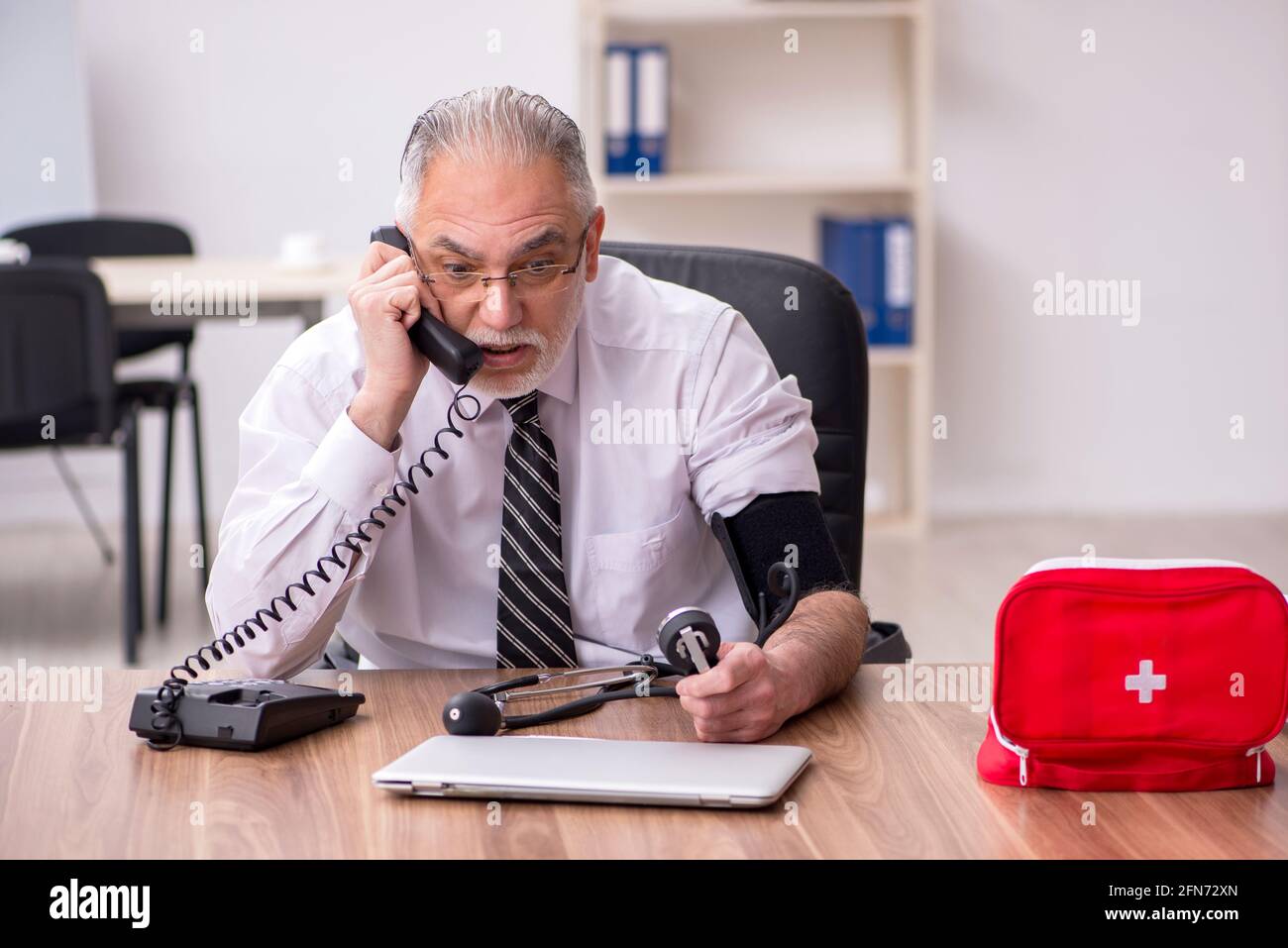 Aged male employee feeling bad in the office Stock Photo - Alamy