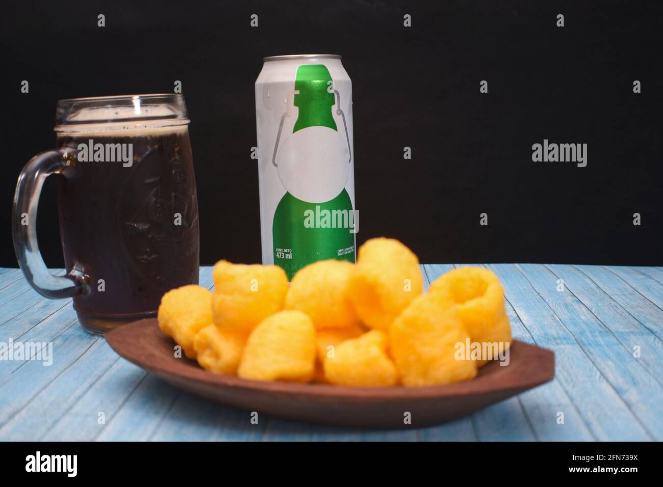 Colorful can of beer on a table with a filled mug and chips Stock Photo ...