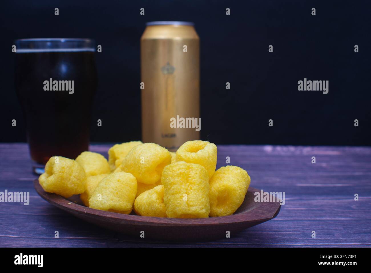 Colorful can of beer on a table with a filled mug and chips Stock Photo ...