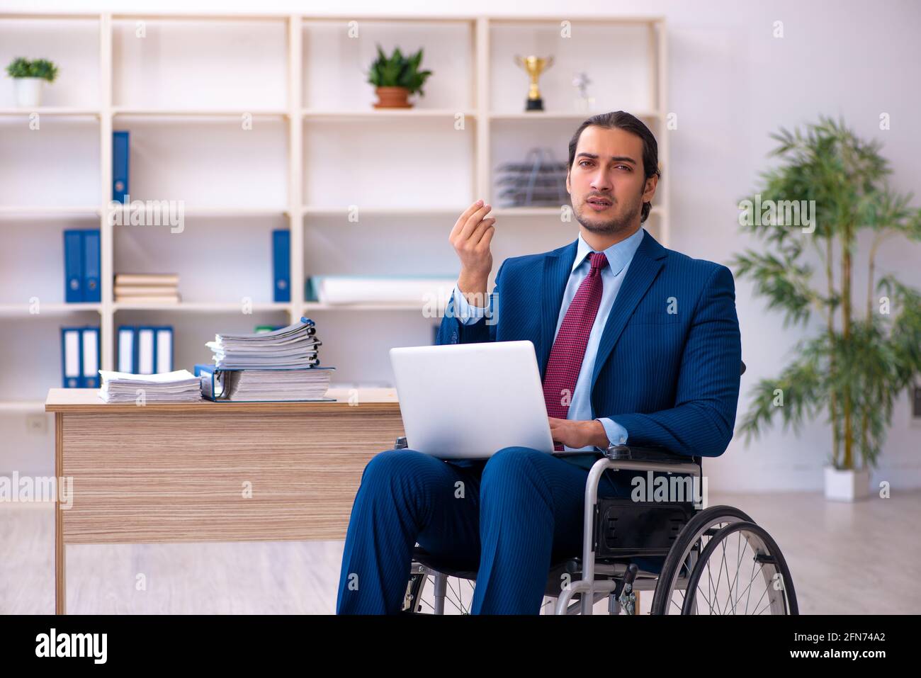 Young male disabled employee working in the office Stock Photo - Alamy