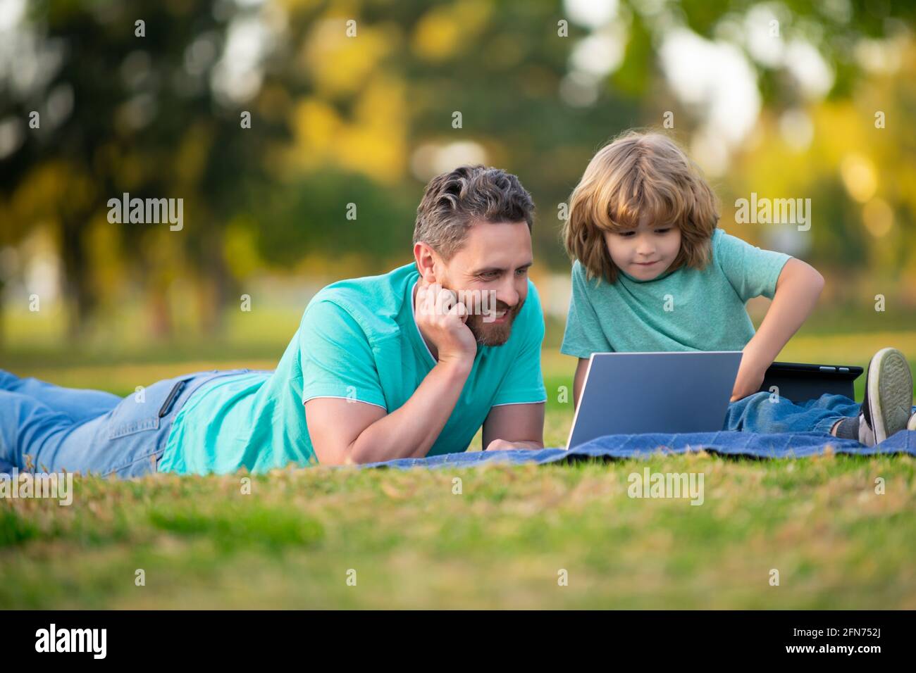 Father teaching son to use laptop dad and school boy child looking ...