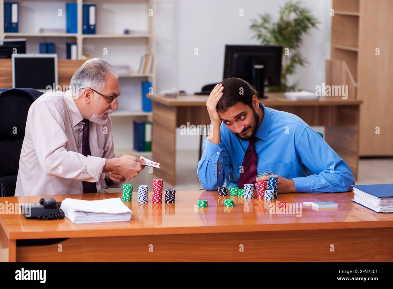 Two employees playing cards at workplace Stock Photo - Alamy