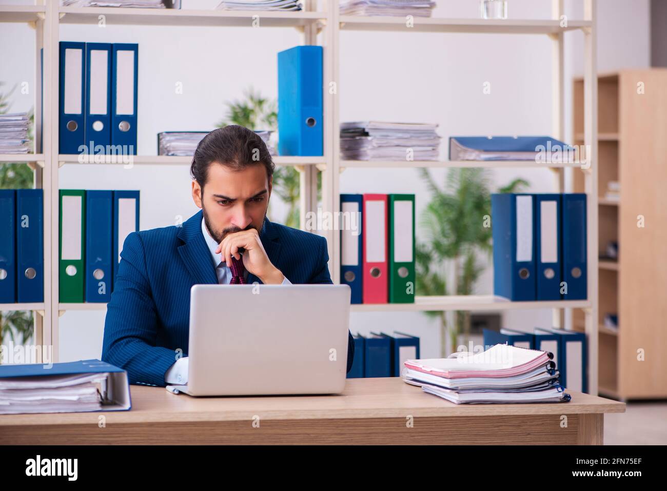 Young employee and too many work in the office Stock Photo - Alamy