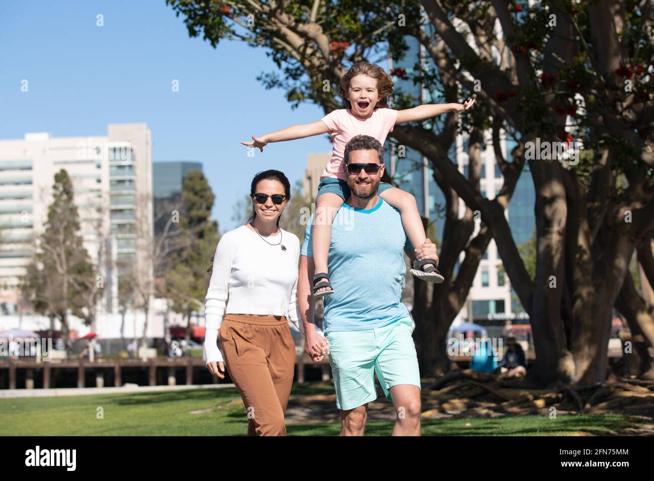 Parents with son walking in the city. Family taking a walk on street ...