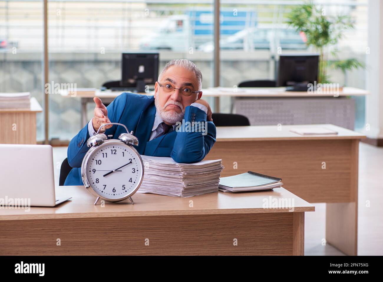 Old boss employee in time management concept Stock Photo - Alamy