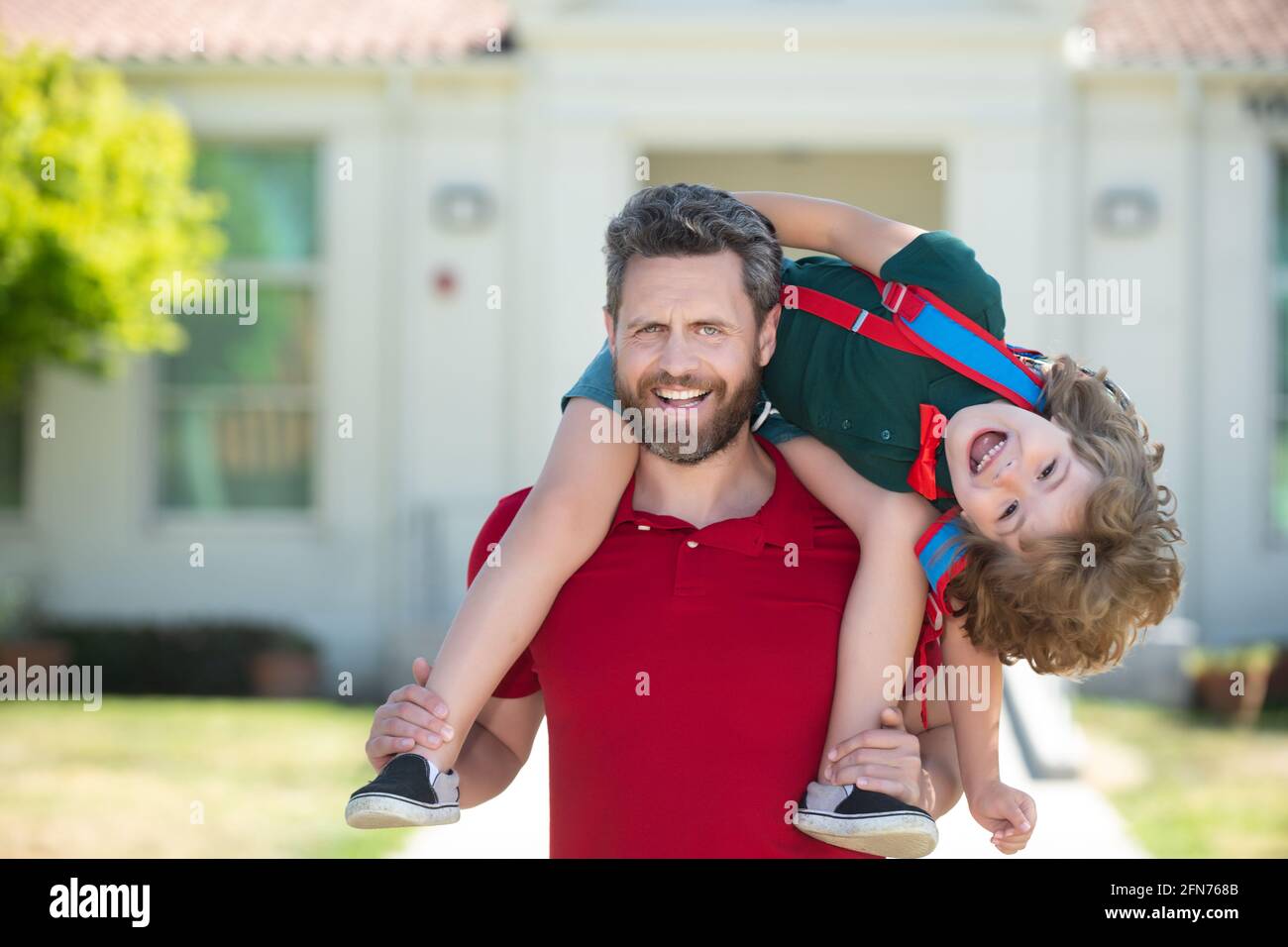 Father giving son piggyback ride after come back from school. School ...