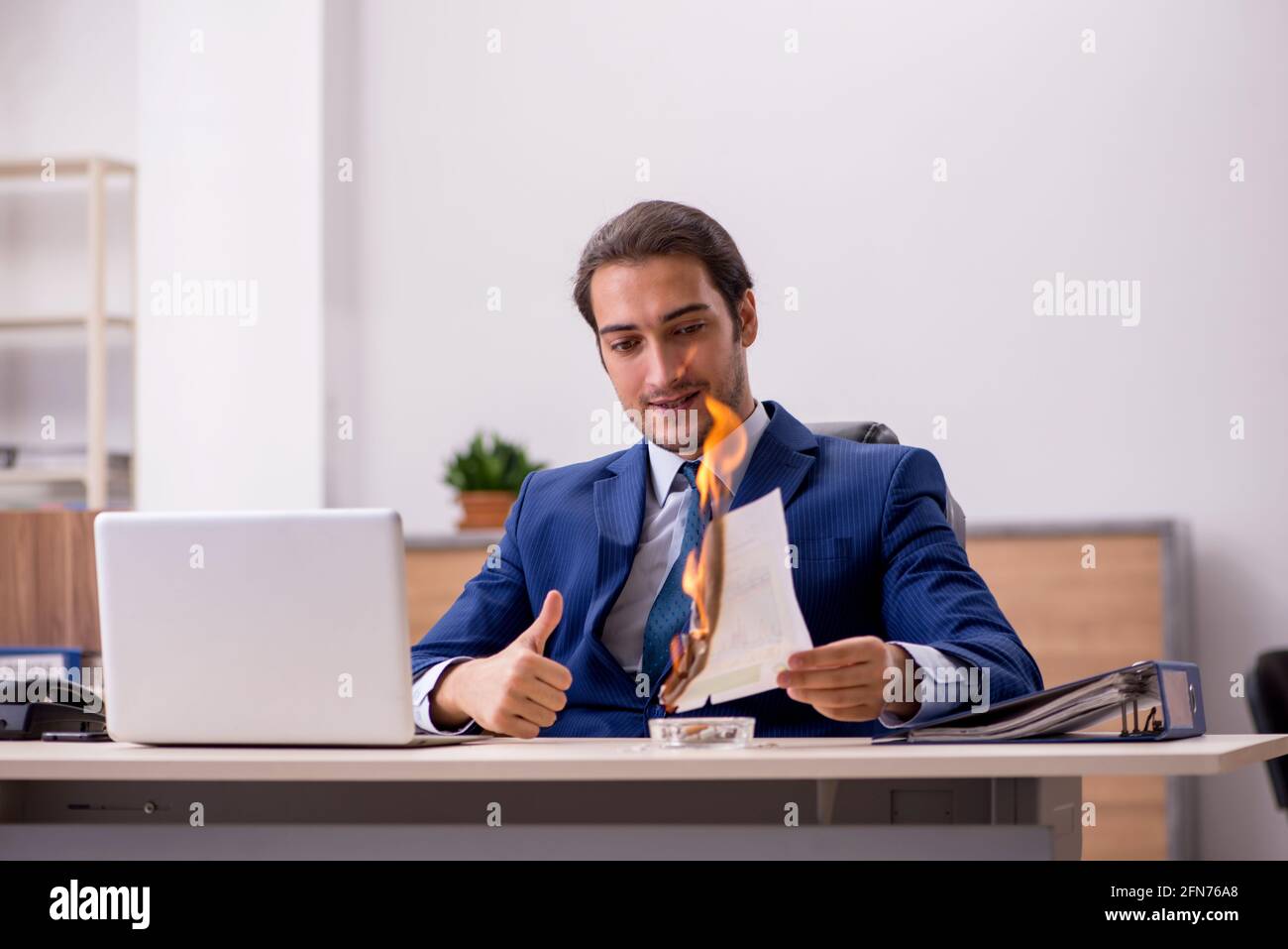 Young man employee burning papers in the office Stock Photo - Alamy