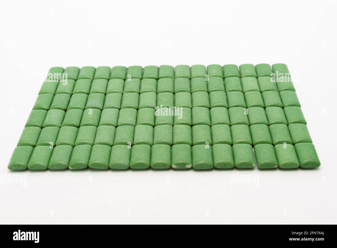 Green mint chewing gum tablets aligned. Isolated on white background ...