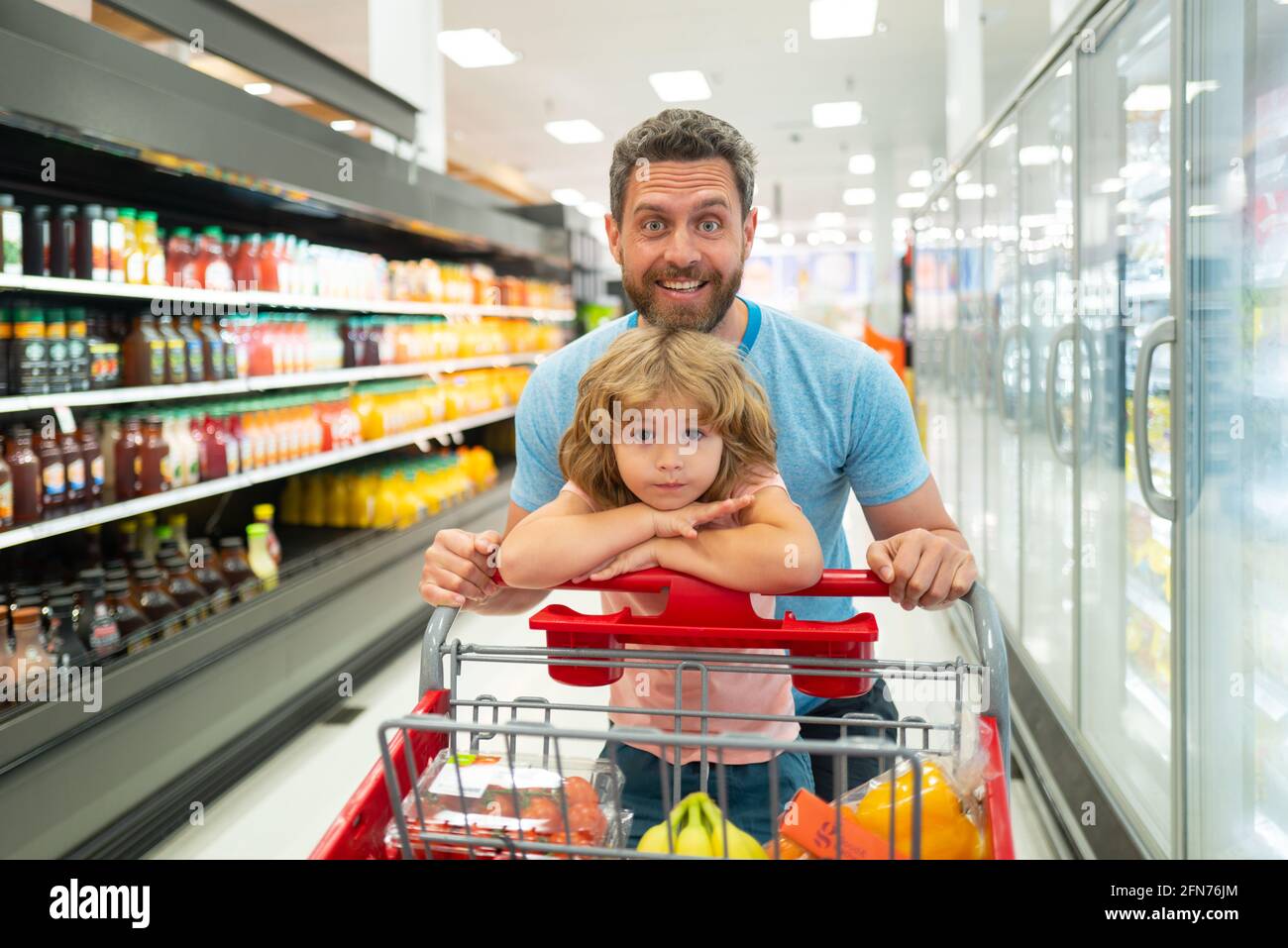 Amazed family father and child son with shopping cart buying food at ...