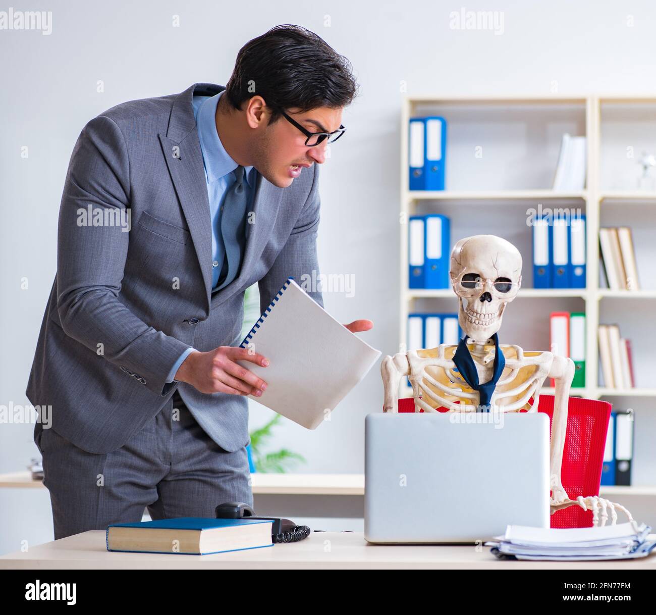 The angry boss yelling at his skeleton employee Stock Photo - Alamy