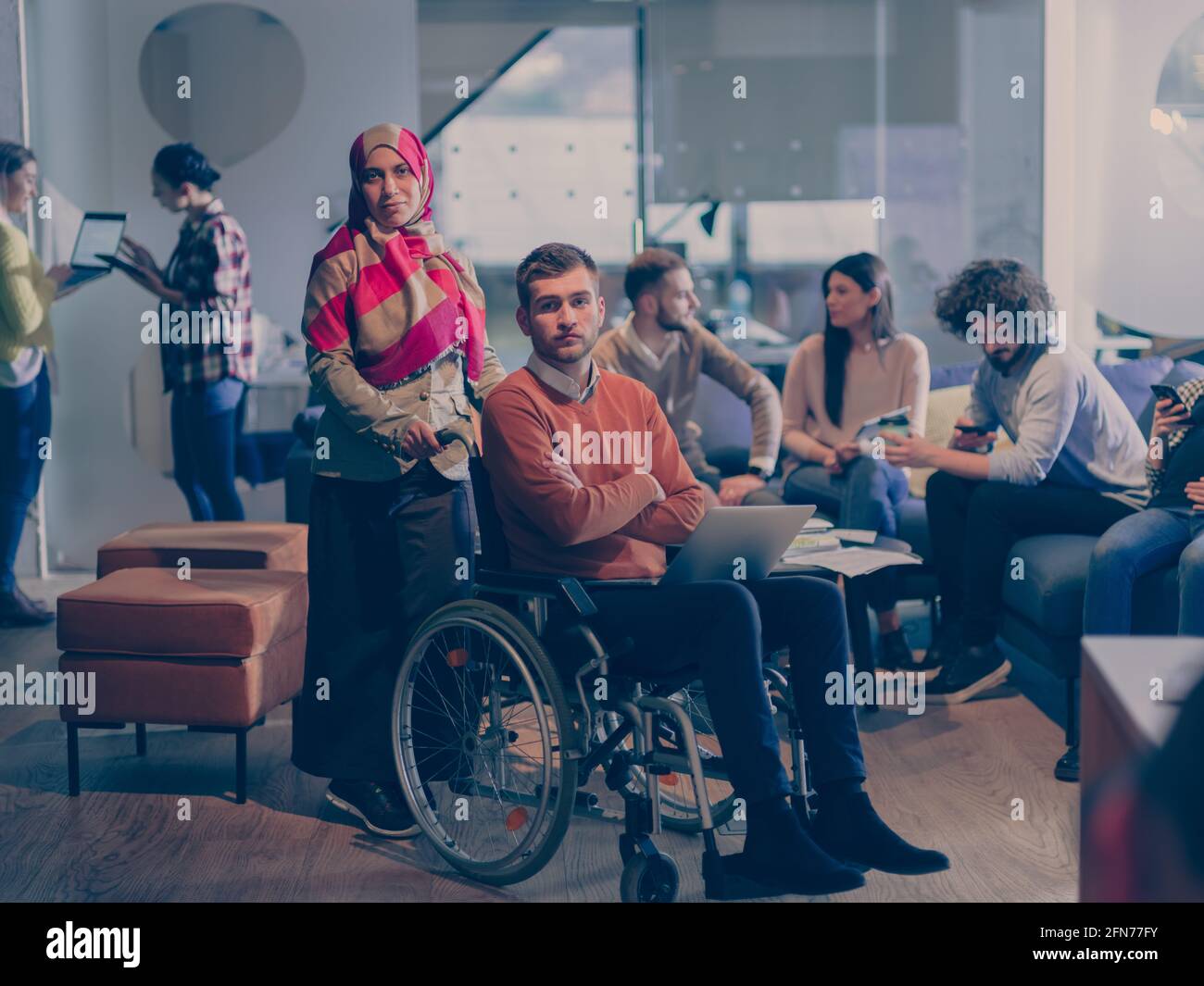 Disabled businessman in a wheelchair at work in modern open space ...