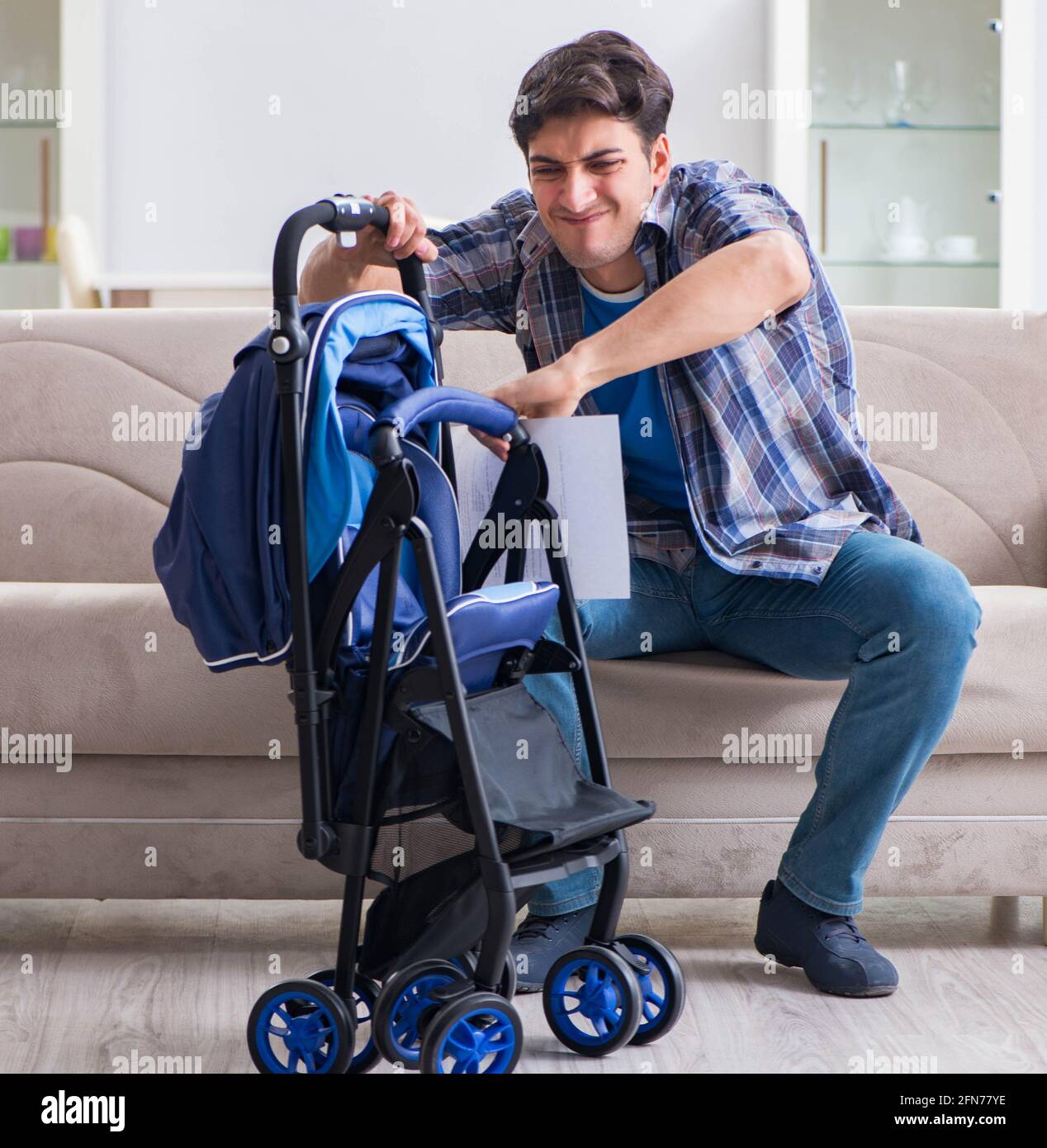 The young father assembling baby pram at home Stock Photo - Alamy