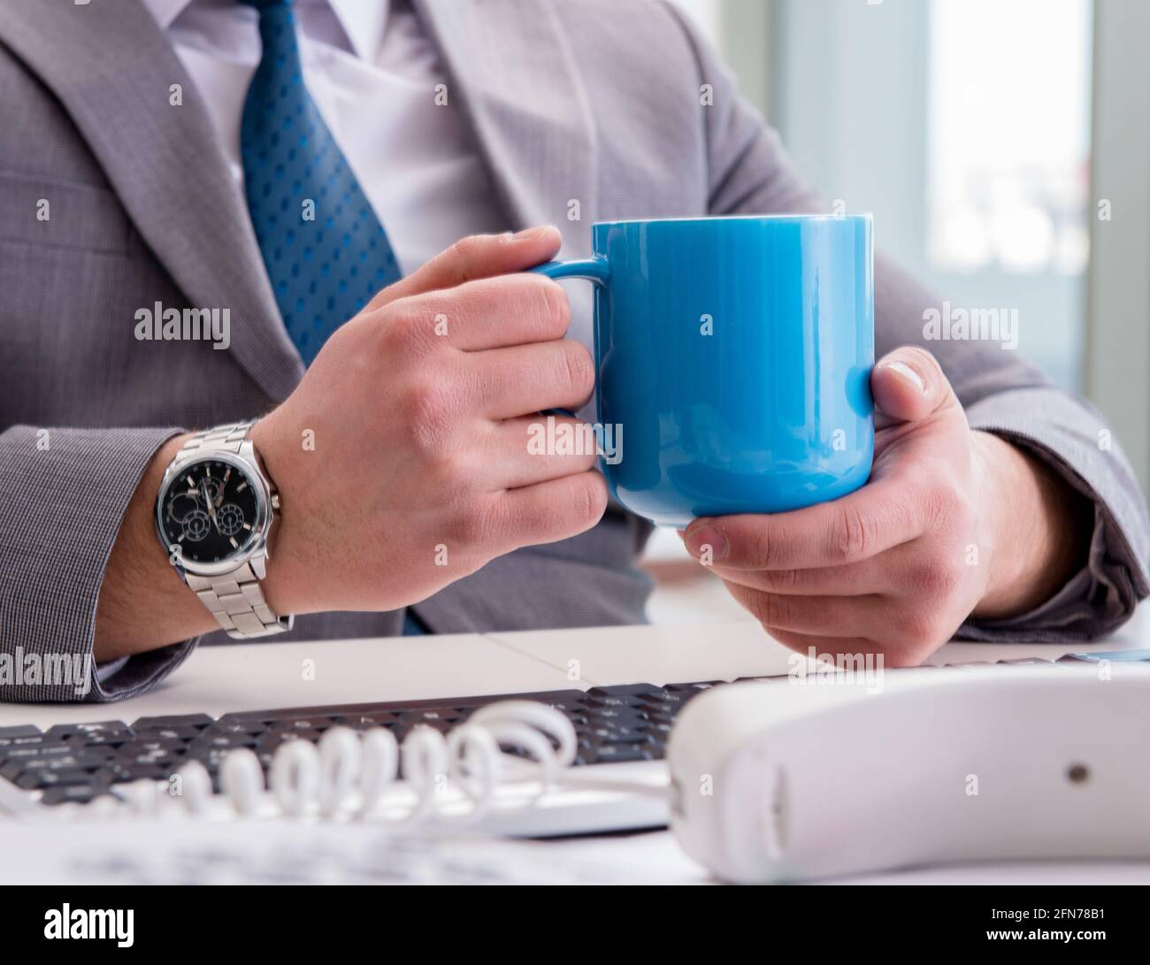 The businessman drinking coffee in the office Stock Photo - Alamy