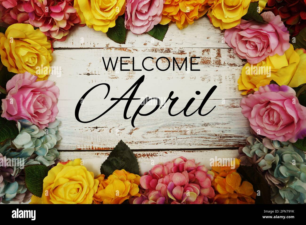 Welcome April text message with flowers border decoration on wooden ...