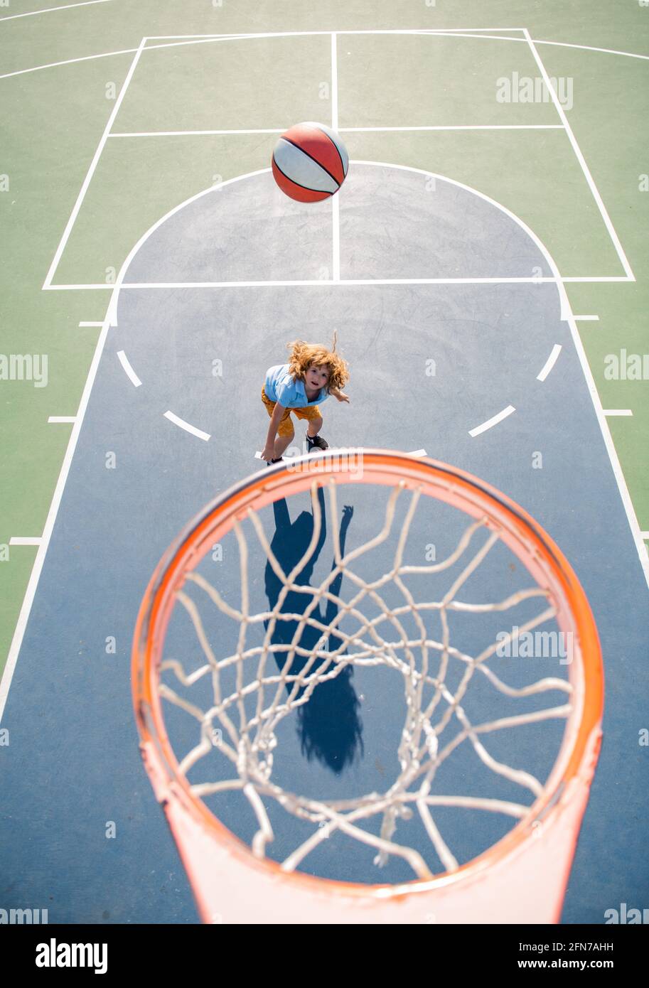 Basketball kids game. Cute little boy holding a basketball ball trying ...