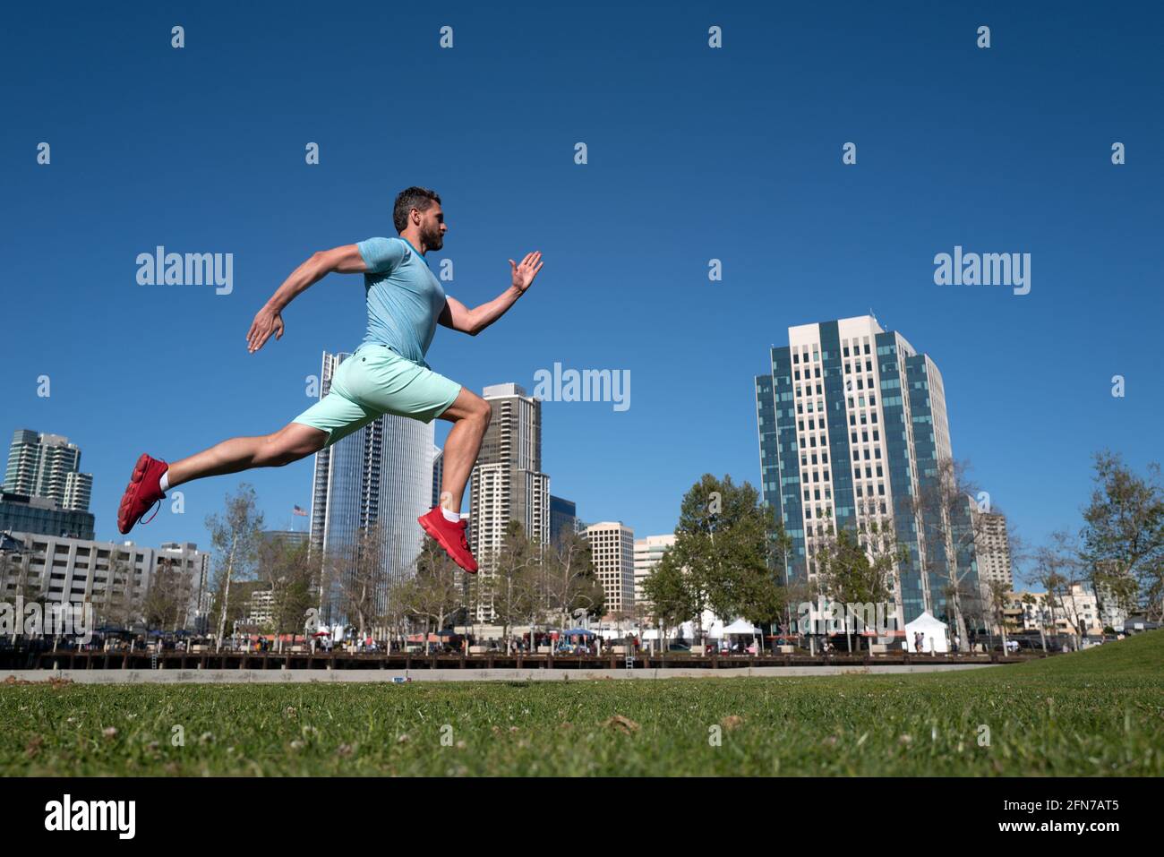 Full length of healthy man running and jogging outdoors. Male model in ...