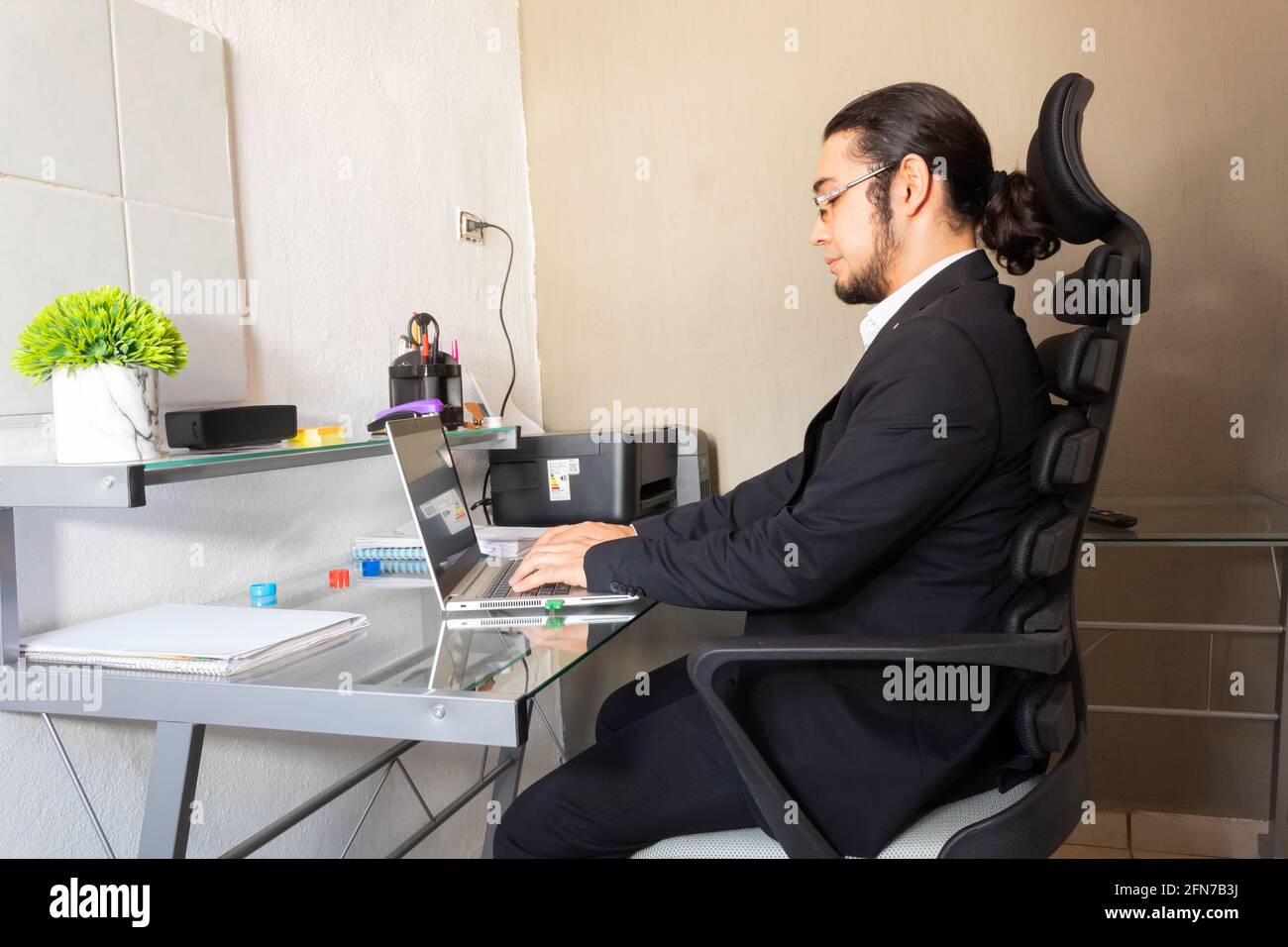 Hispanic young man in a black suit doing home office at his desk Stock ...