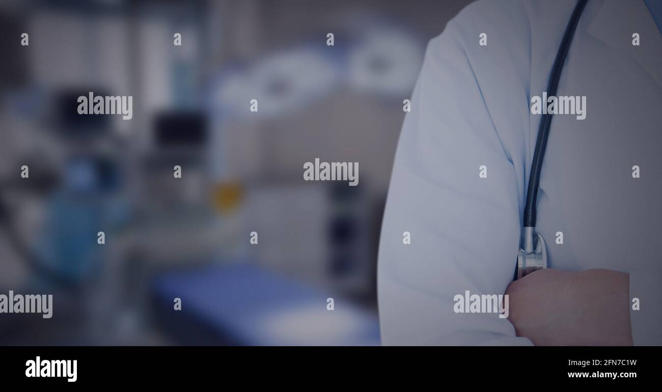 Mid section of male doctor with arms crossed against operation theatre ...