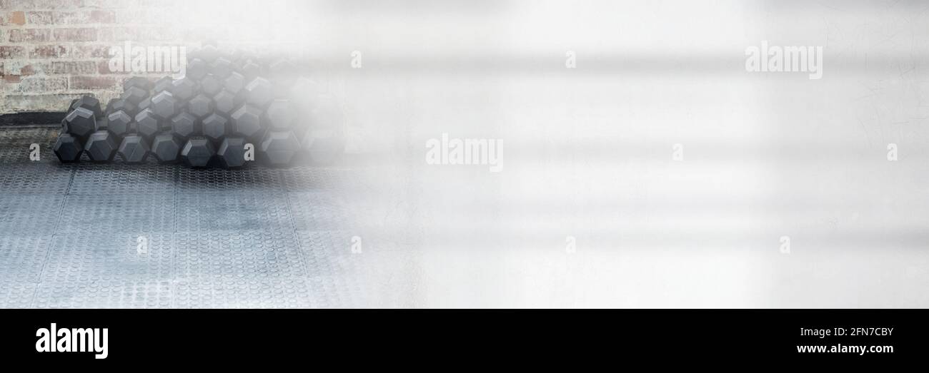 Composition of stack of dumbbells on gym floor with blurred grey light ...