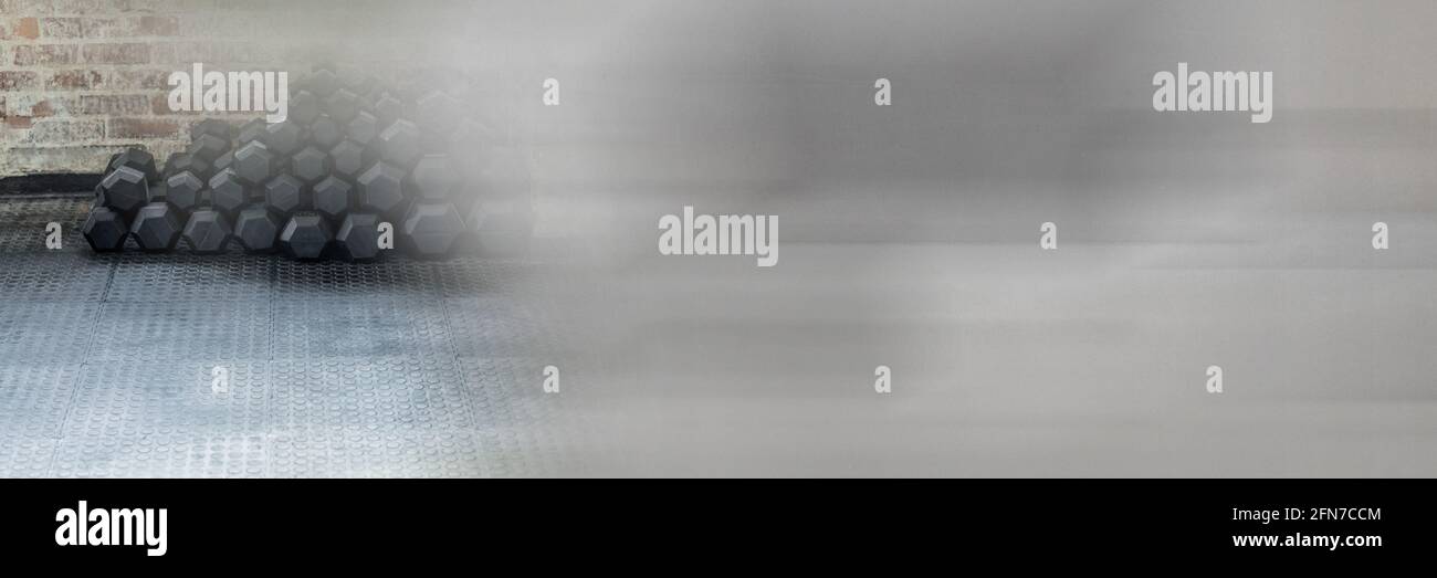 Composition of stack of dumbbells on gym floor with blurred grey light ...
