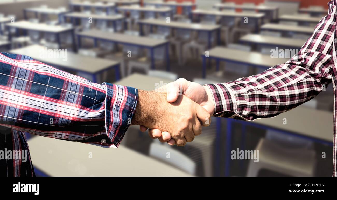 Composition of men shaking hands in classroom Stock Photo - Alamy