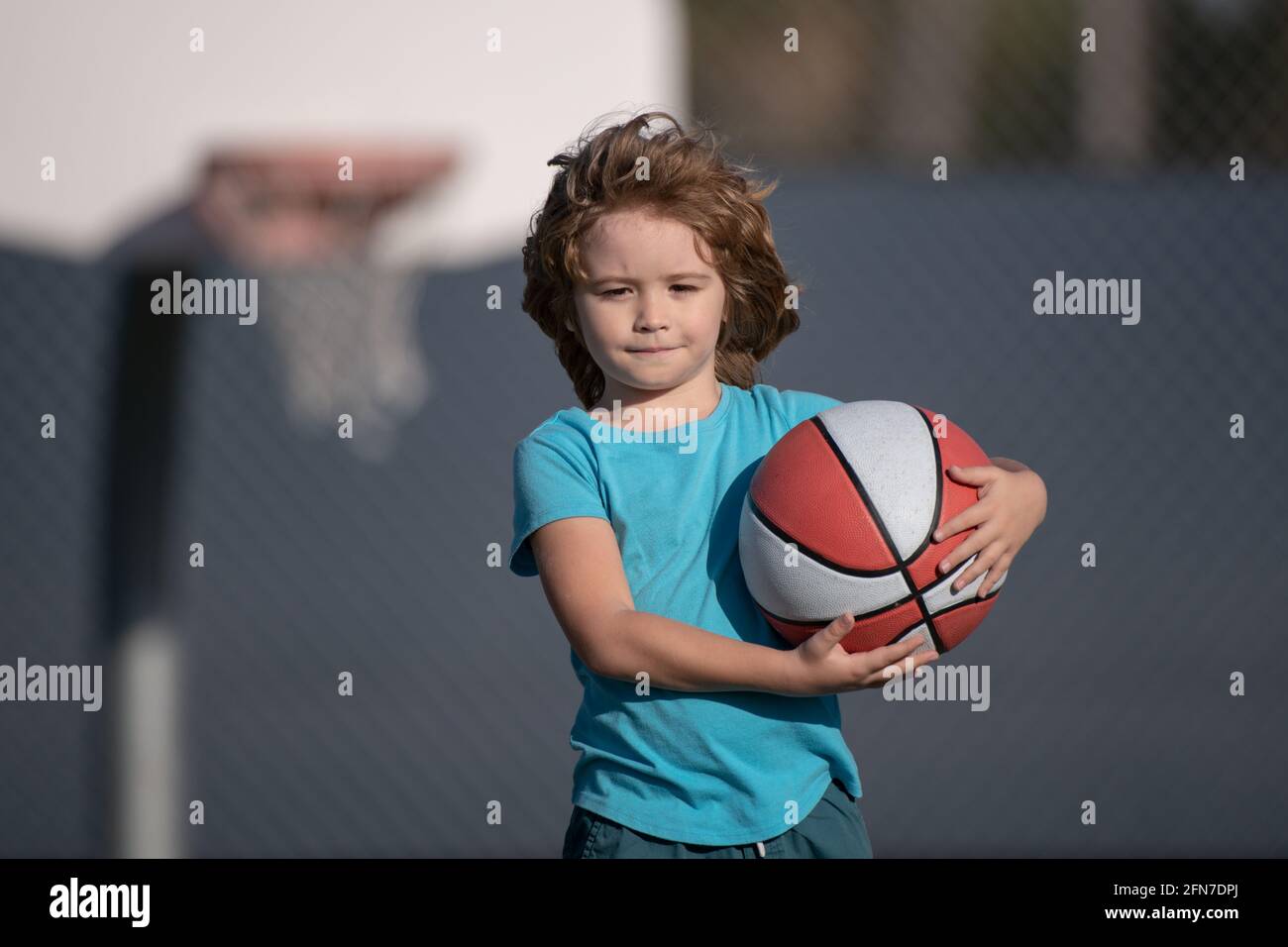 Kid playing basketball with basket ball. Kid posing with a basketball ...