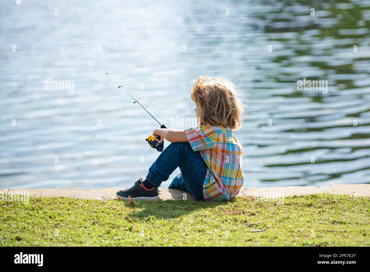 Kid fisher. Boy with spinner at river. Portrait of excited boy fishing ...