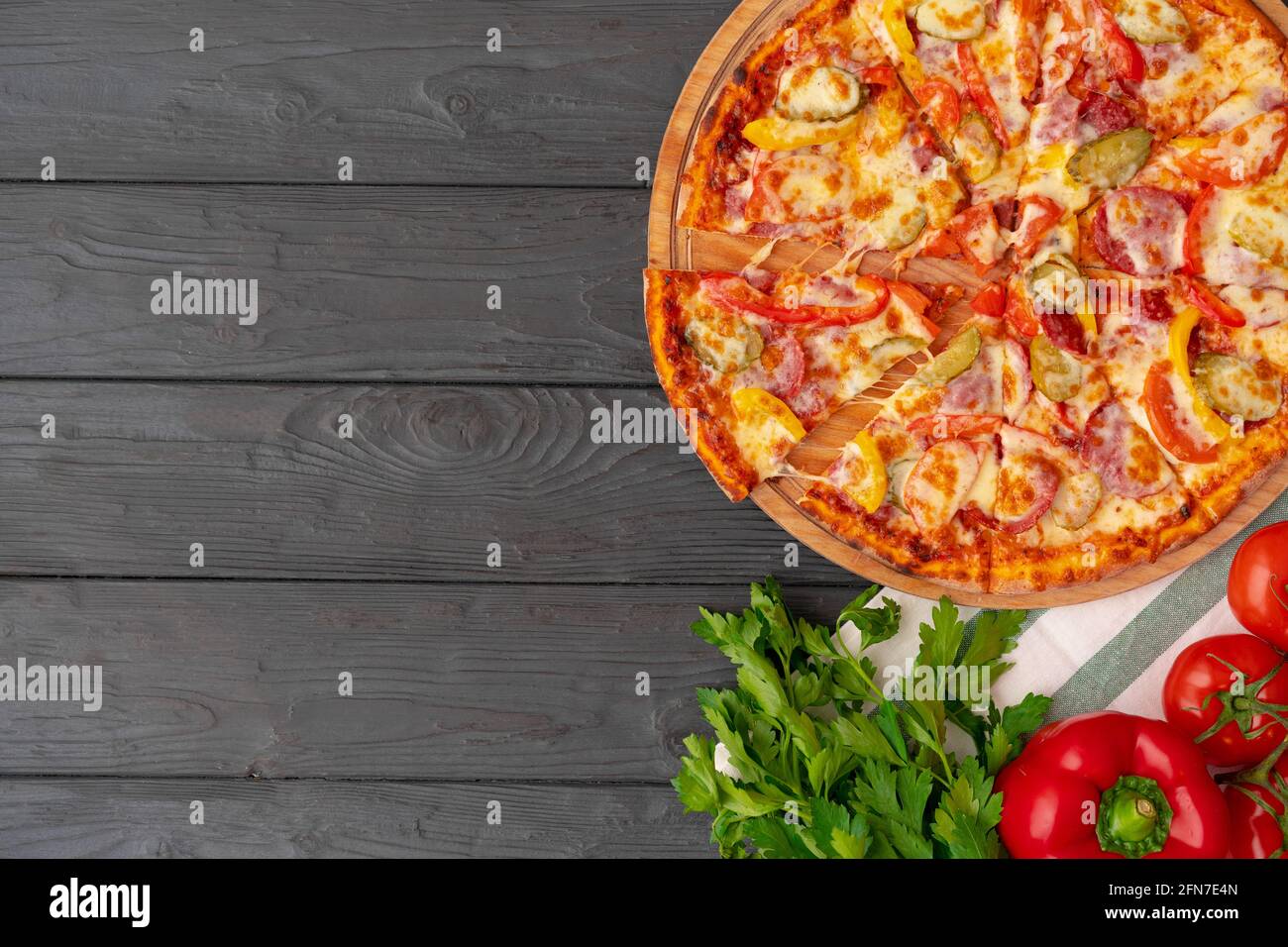 Top view of hot pizza on black wooden table Stock Photo - Alamy
