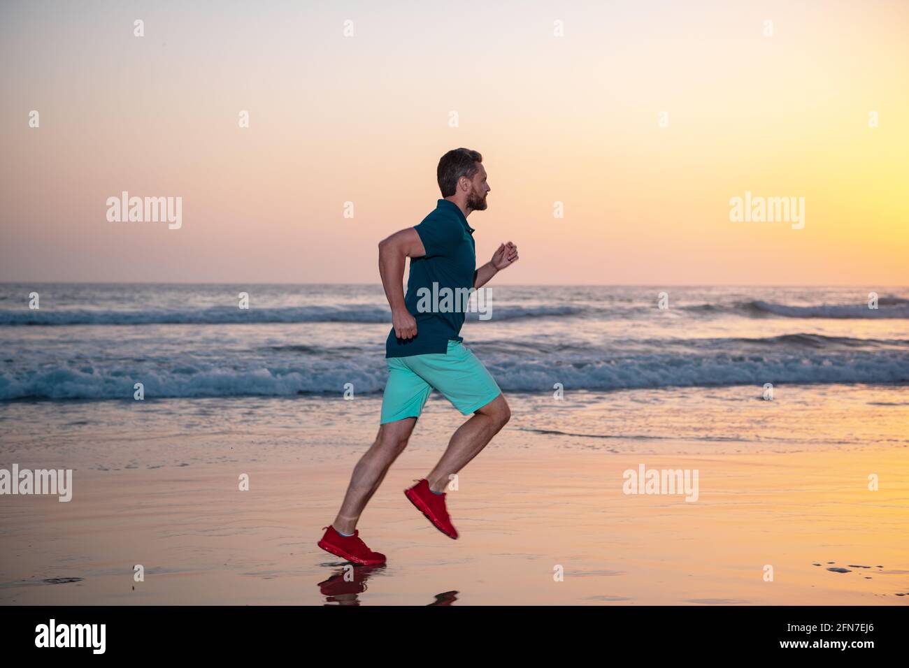 Sporty man runner running in summer beach, colorful sunset sky Stock ...
