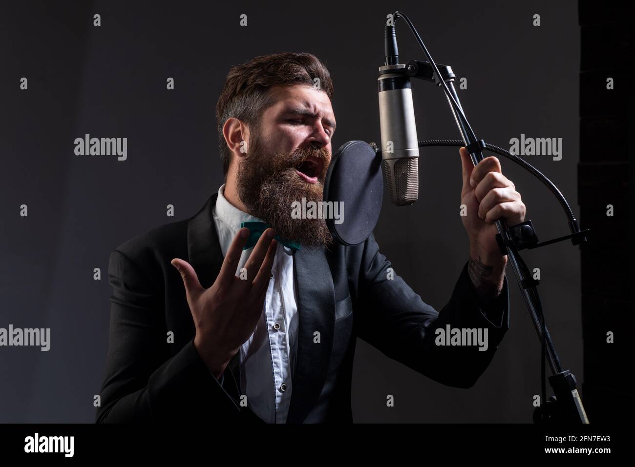 Man with microphone singing in music hall Stock Photo - Alamy