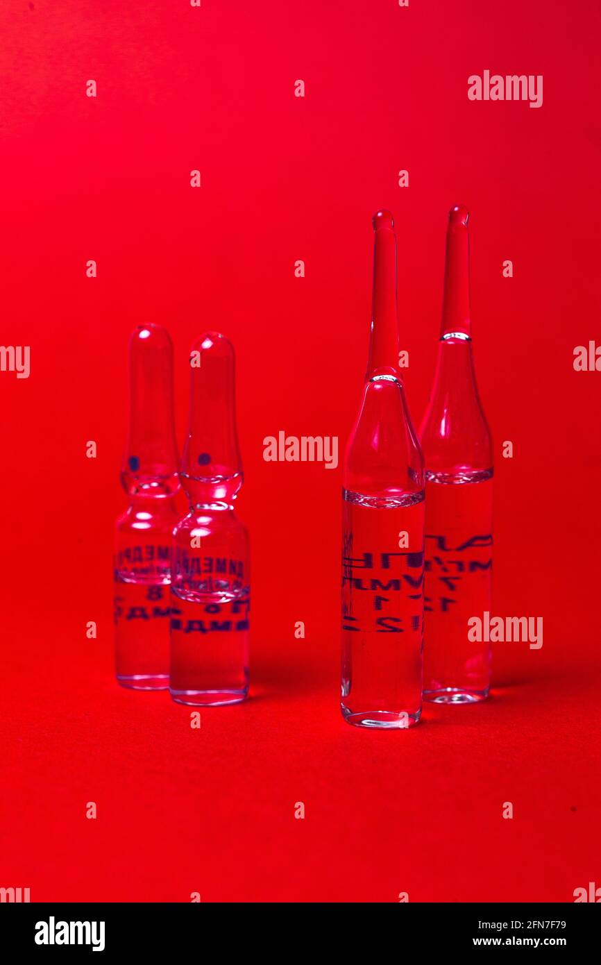 four vials with injection medicine on a red background Stock Photo - Alamy