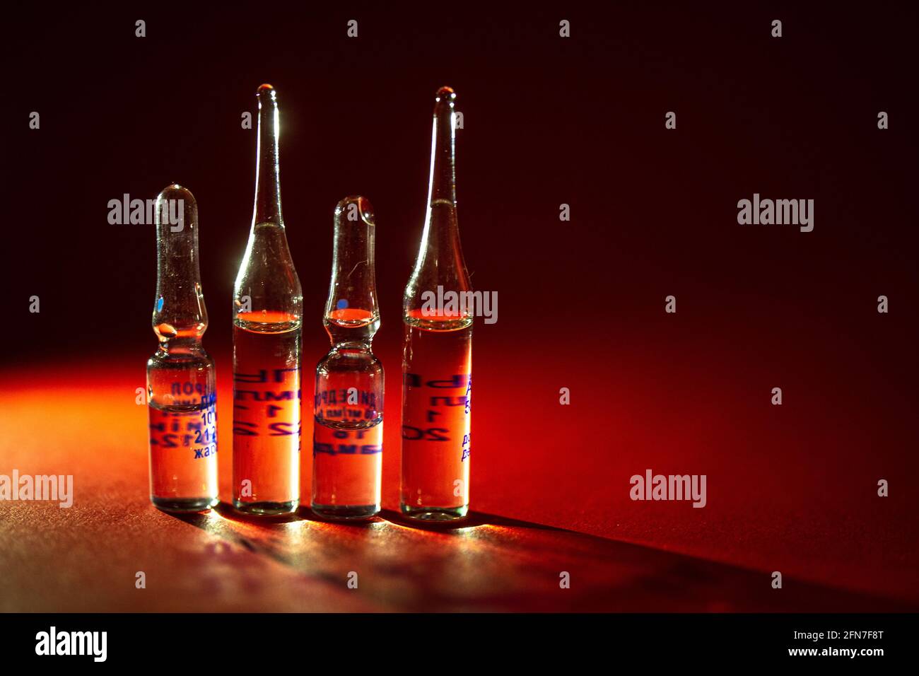 four vials with injection medicine on a red background Stock Photo - Alamy